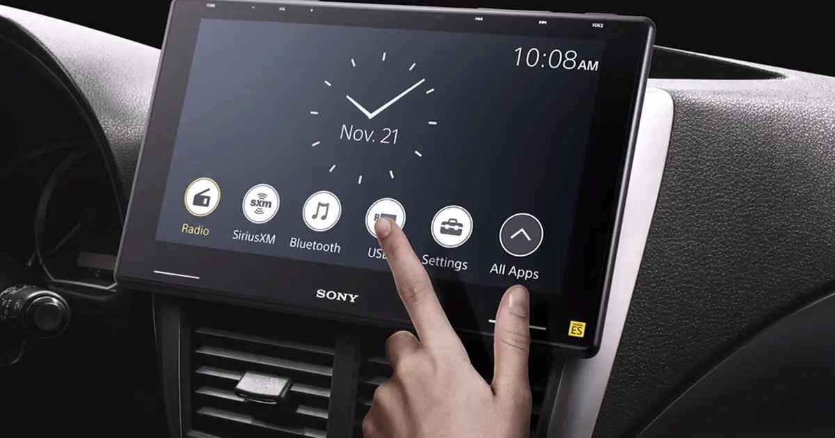 A person touching a button onscreen a sony car audio screen system ...